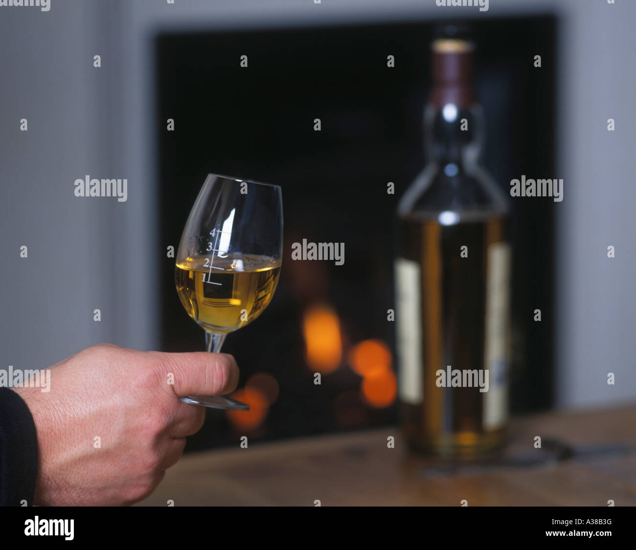Malt whisky swirling in nosing glass by fireside Stock Photo - Alamy