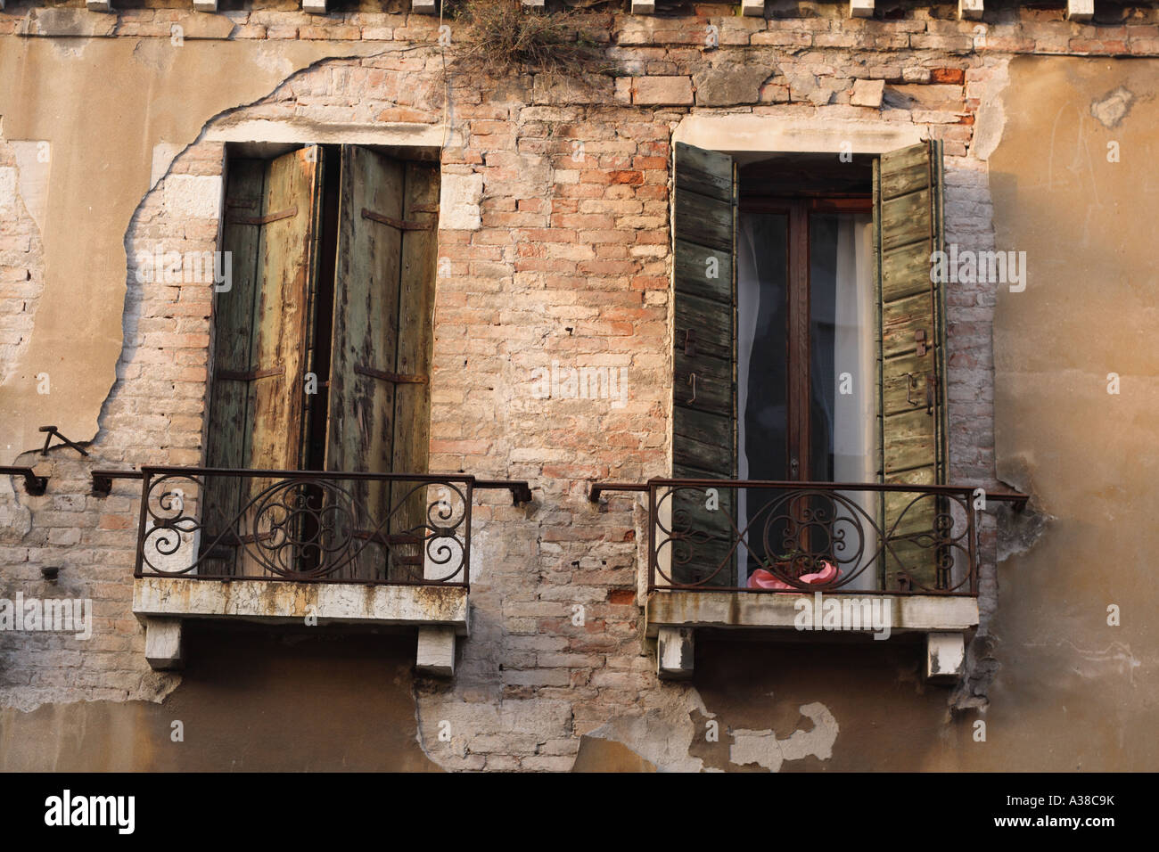 Windows with balconies on the side of a house showing erosion from salt ...