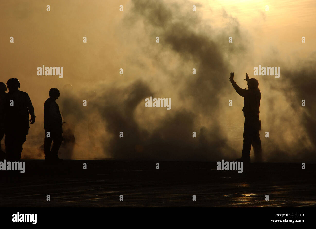 Steam envelopes the flight deck crew aboard an aircraft carrier during ...