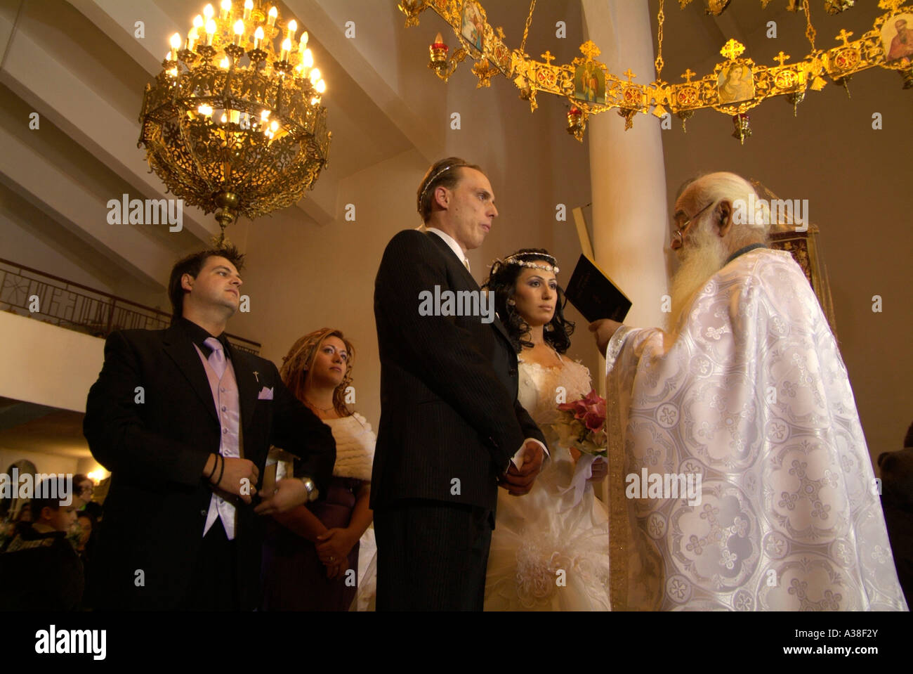 During a Greek Orthodox Wedding Ceremony a couple is listening ...