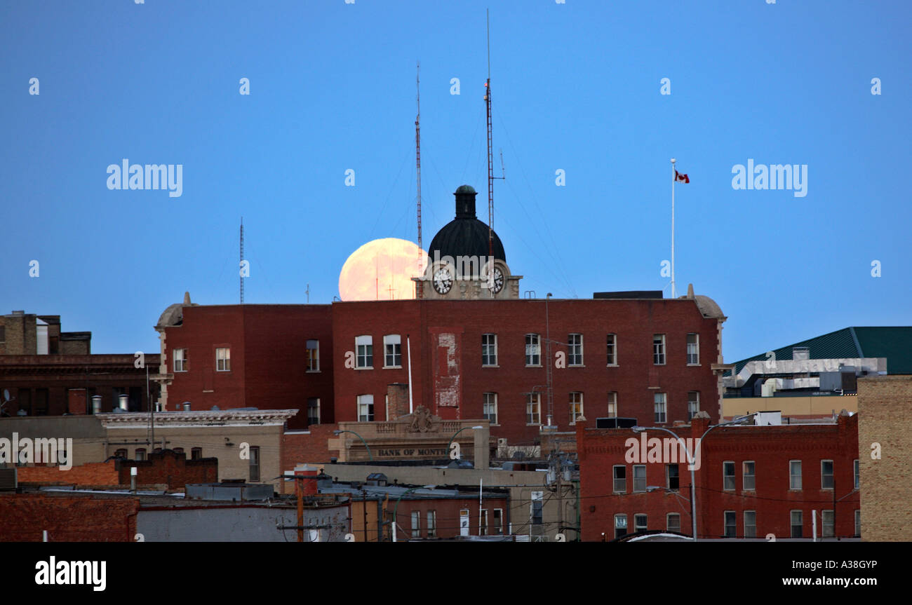 full moon rising over city buildings Stock Photo - Alamy