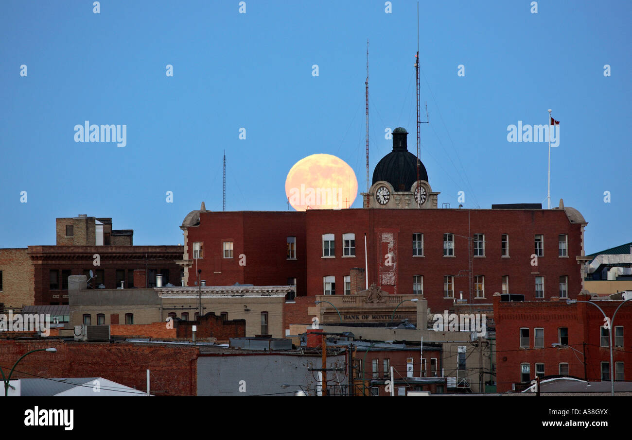 full moon rising over buildings Stock Photo - Alamy