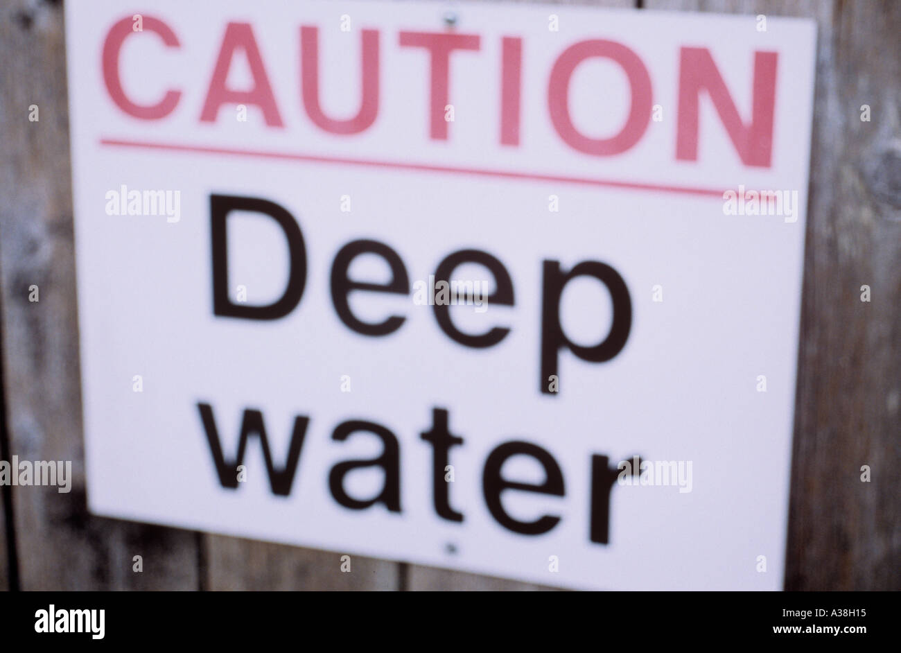 Defocussed sign warning Caution Deep water Stock Photo - Alamy