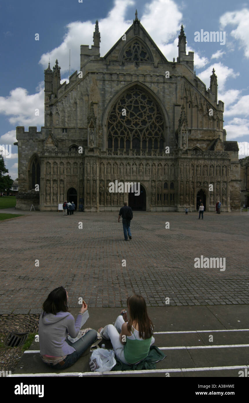 Two girls picnic on steps in front of Exeter Cathedral Stock Photo - Alamy