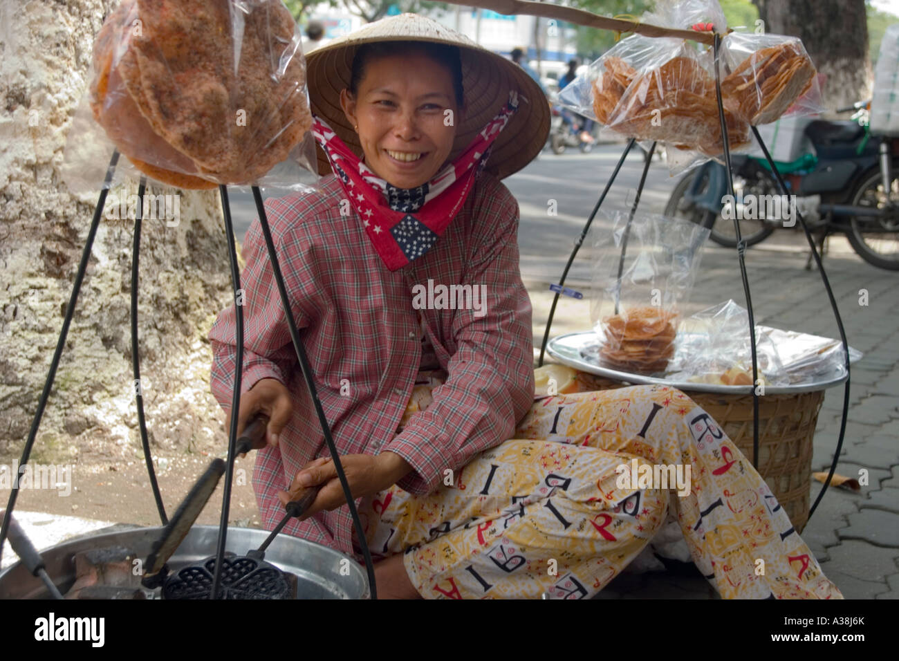 Yoke lady selling waffles in Saigon Stock Photo - Alamy