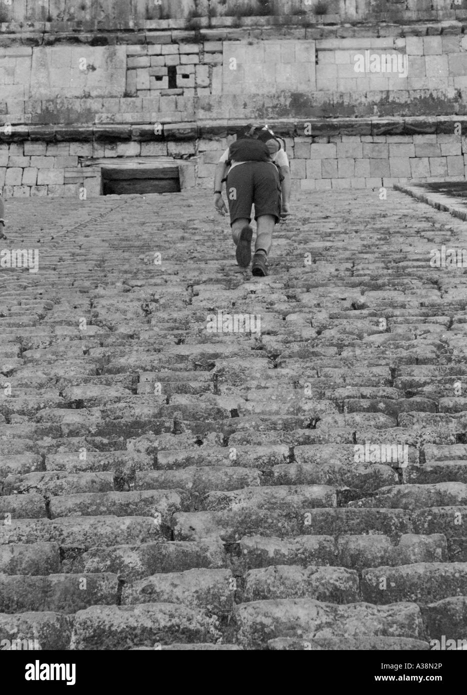 Tourist climbing steps to top of El Castillo Pyramid, Chichen Itza ...