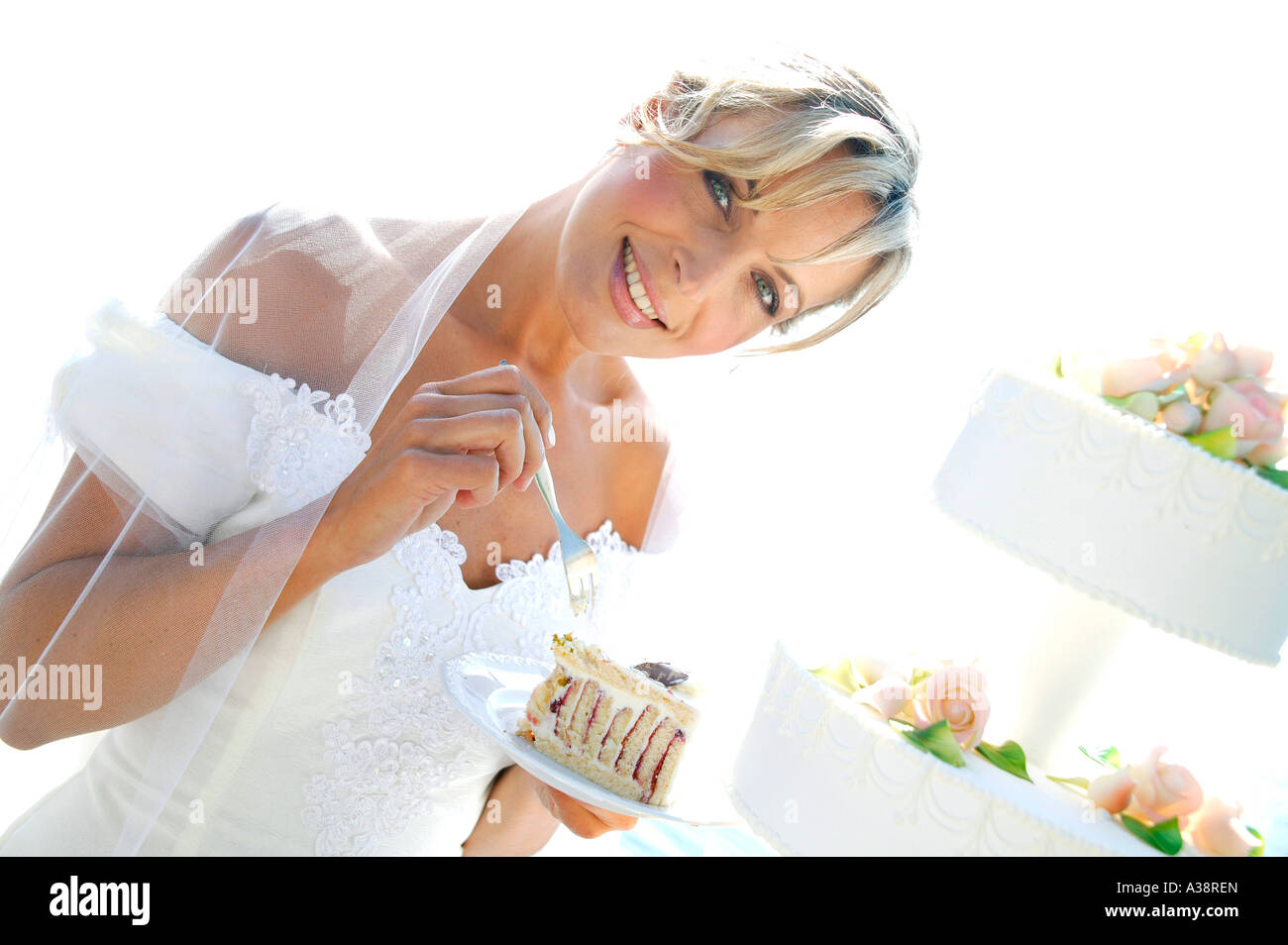 beautiful bride in white wedding dress eating cake Stock Photo - Alamy