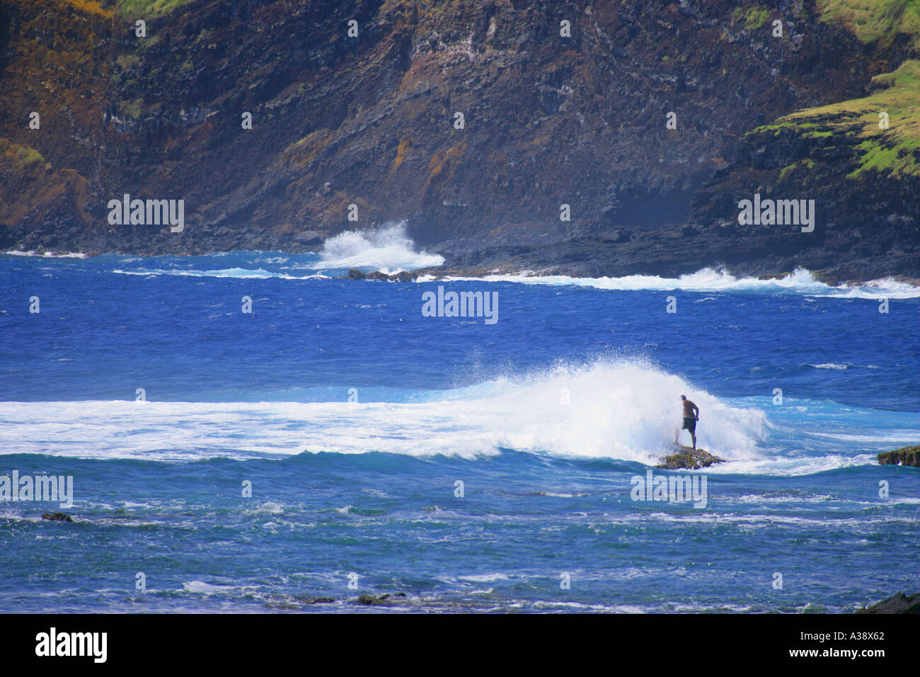 Man standing as wave hits him Stock Photo - Alamy