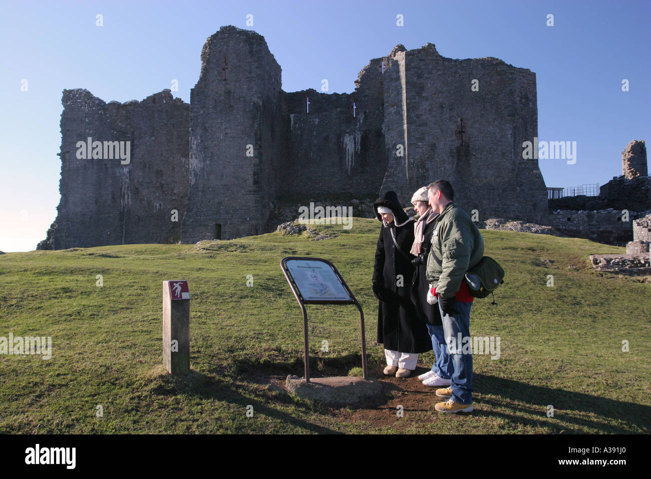 Tourists read the historical information board before entering ancient ...
