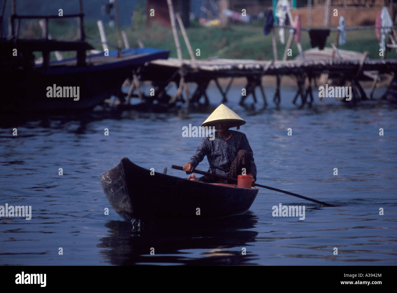 A local person paddling along in their boat Stock Photo - Alamy