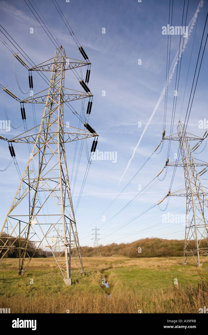 Power transmission lines and pylons against a blue sky with light cloud ...