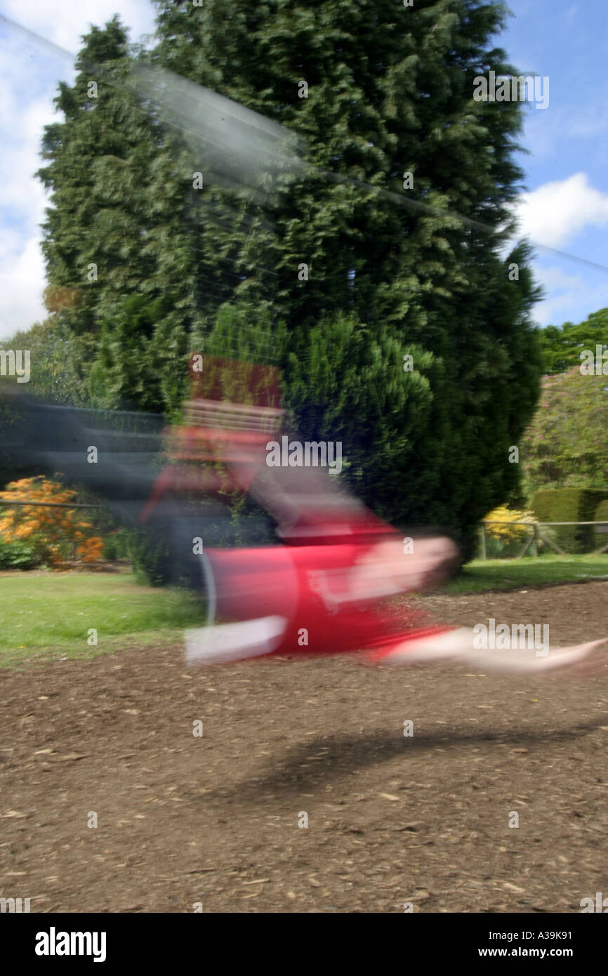 Blurred youth enjoying a rope slide in a childrens playground Vertical ...