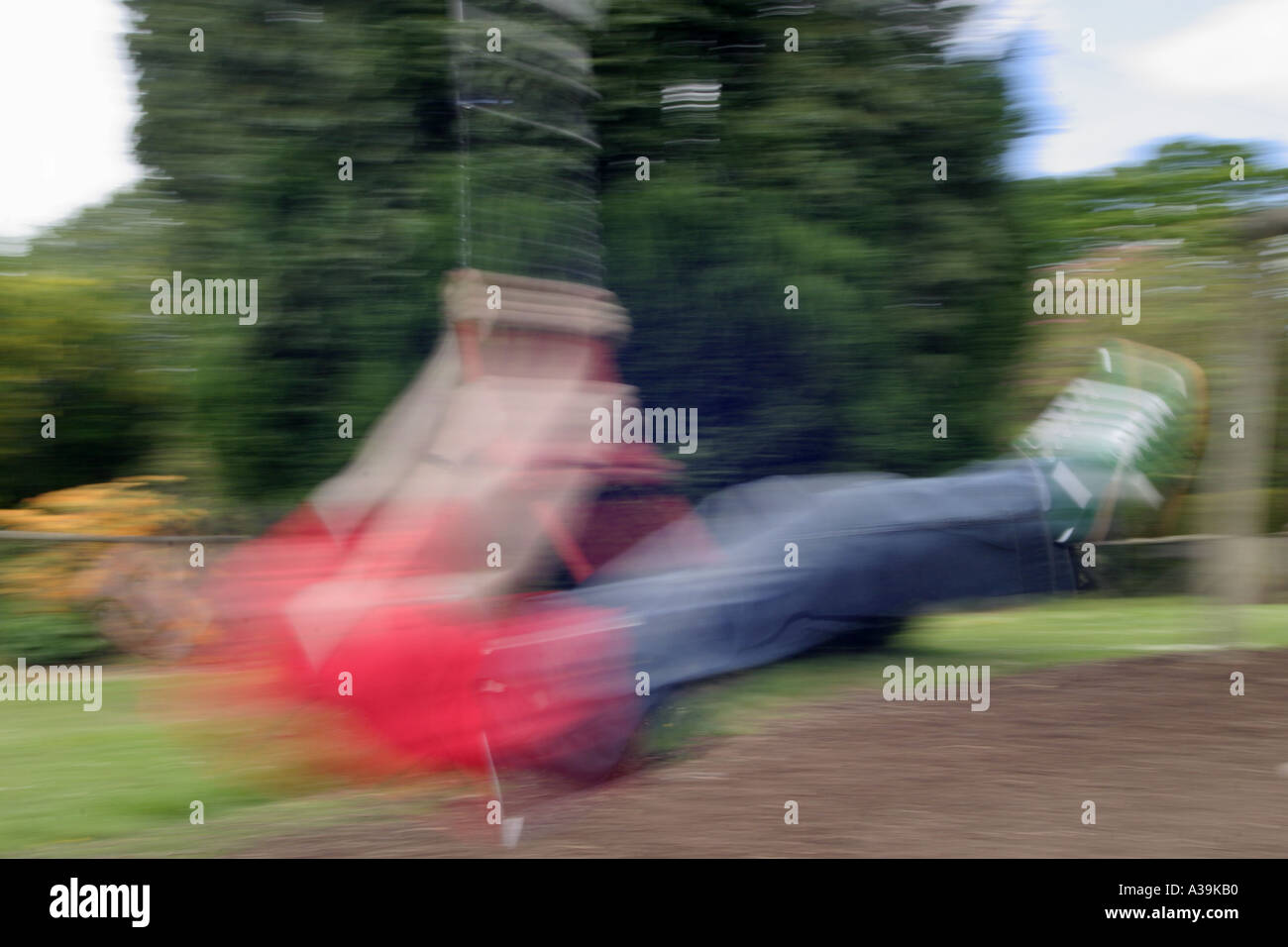 Blurred youth enjoying a rope slide in a childrens playground ...
