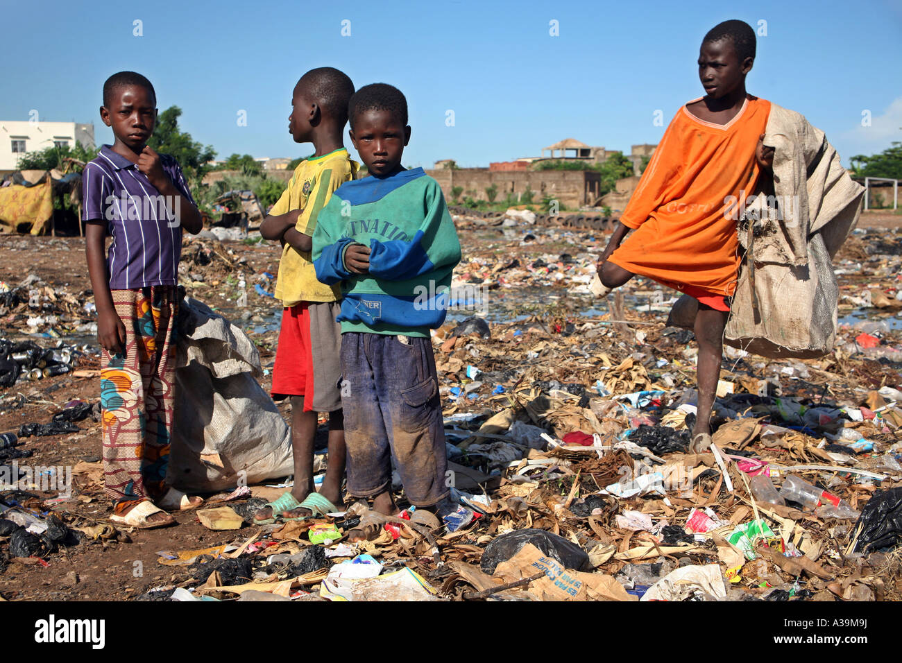 Young boys scavenge through a waste dump looking for plastic to recycle ...
