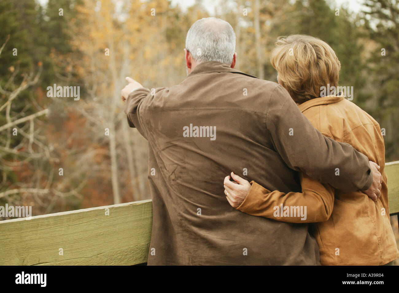 Couple pointing to trees Stock Photo - Alamy