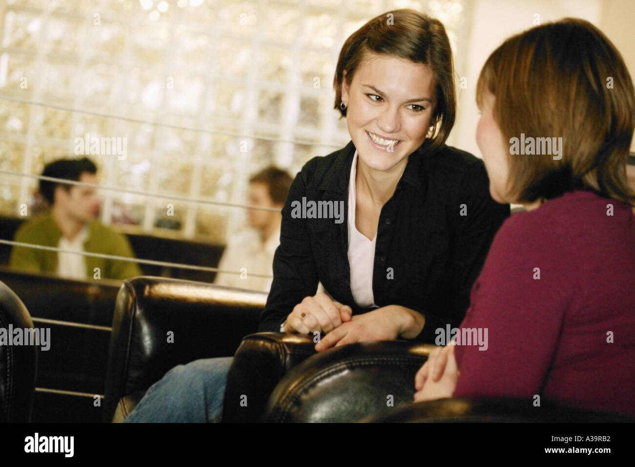 Two young women having a chat Stock Photo - Alamy