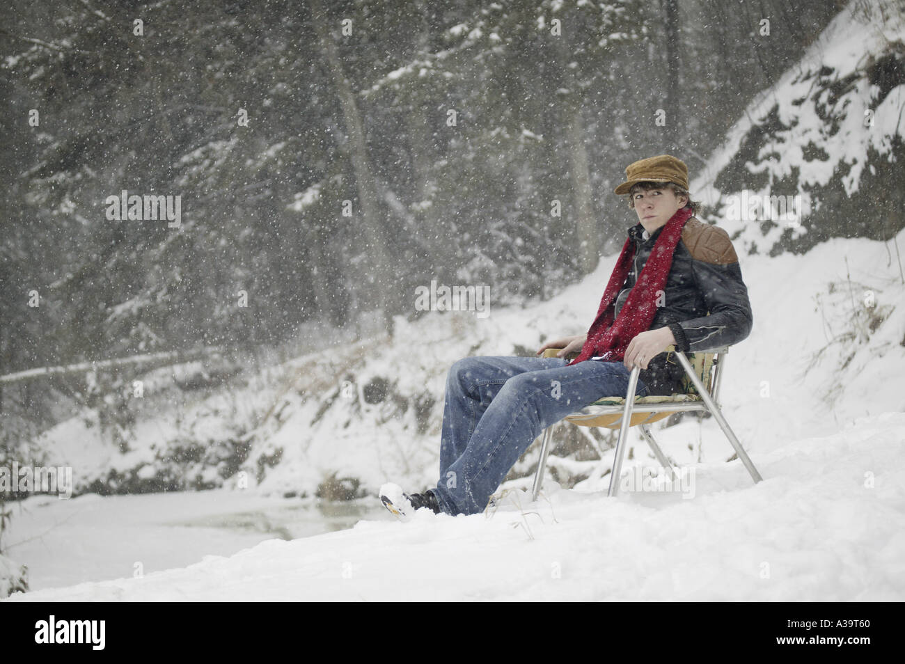 Man sitting in chair as it snows Stock Photo - Alamy