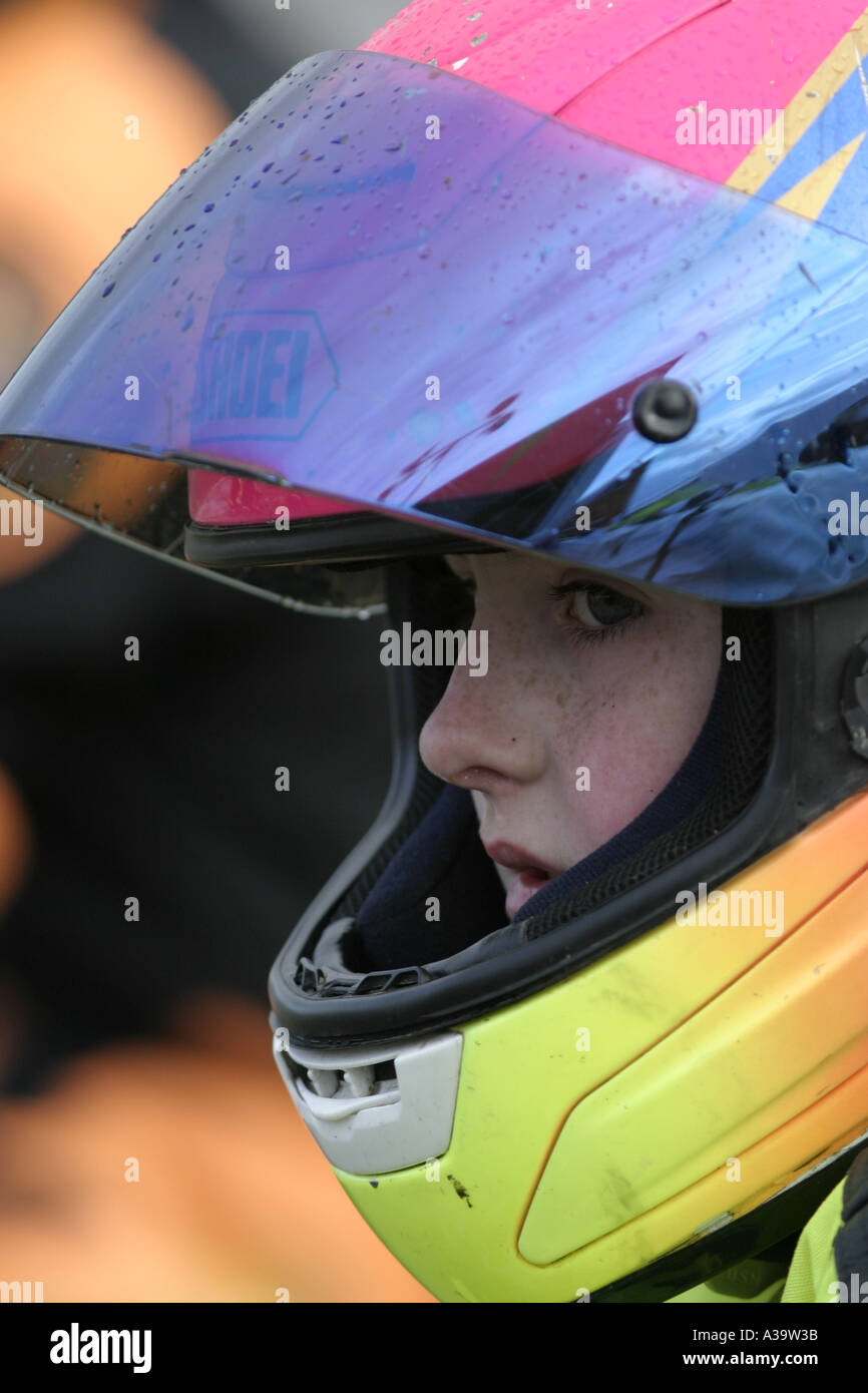 Child motorsport competitor with colourful colorful helmet and visor up ...