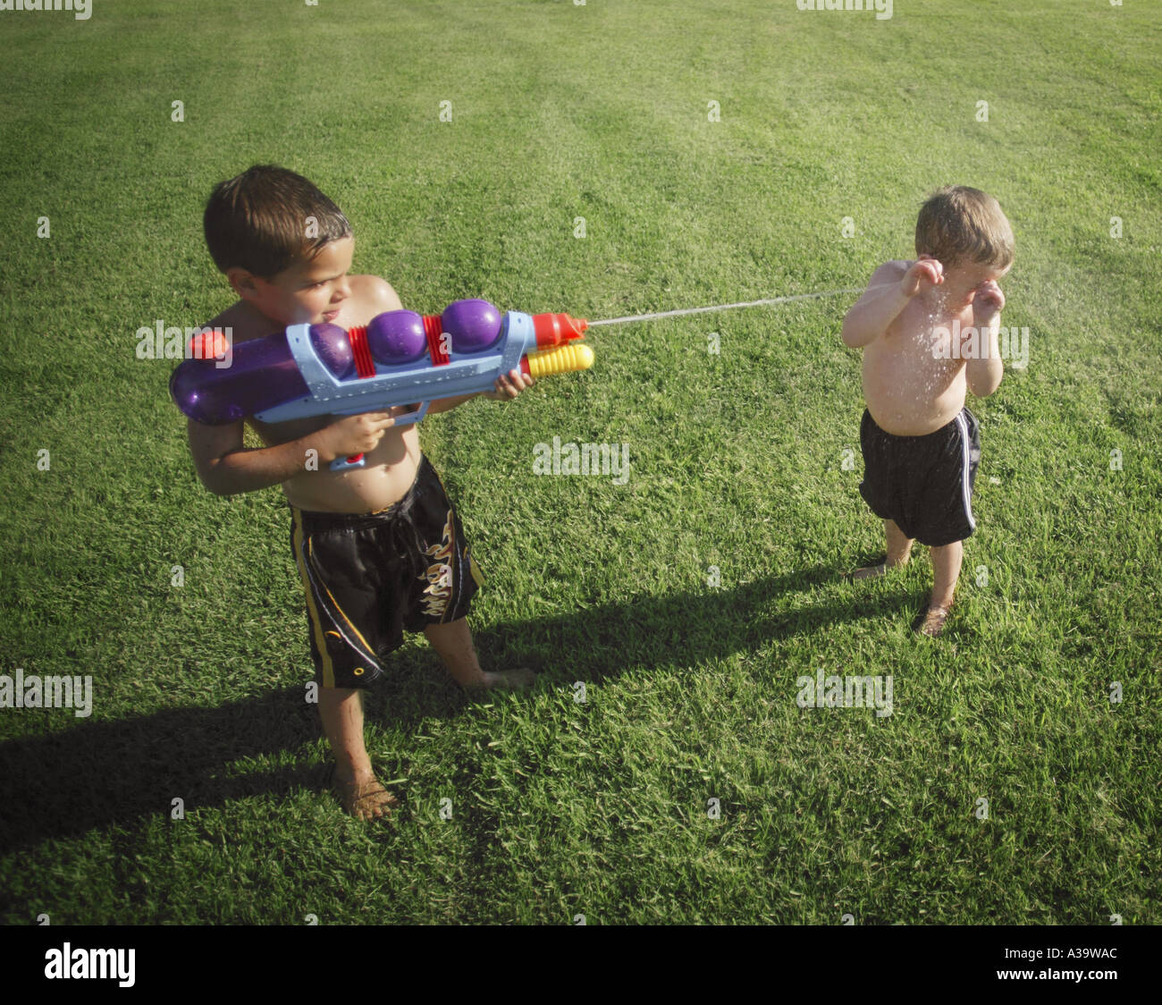 Boy spraying another Stock Photo - Alamy
