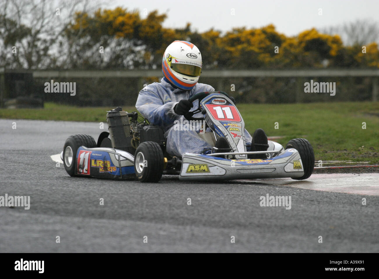 Junior Jnr rotax kart driver lifts a wheel on a kerb whilst racing at a ...