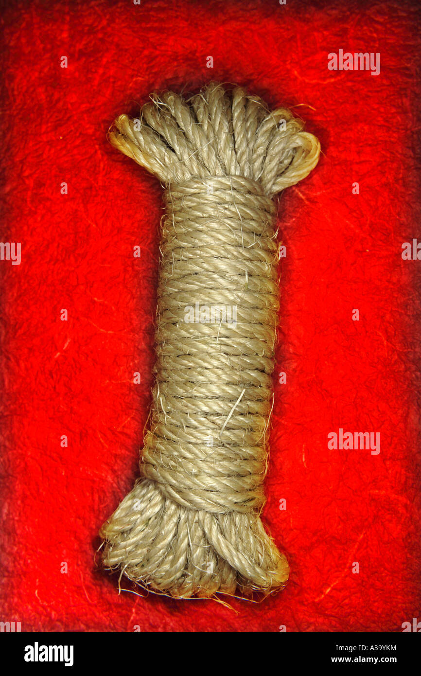 Rope on red background Stock Photo - Alamy