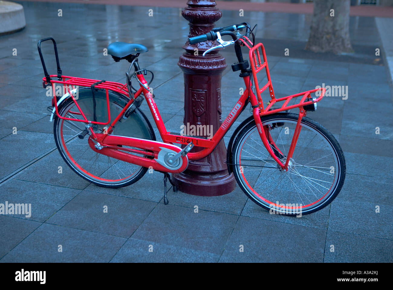 Red Delivery bike parked on pavement on a wet day in Amsterdam Stock ...