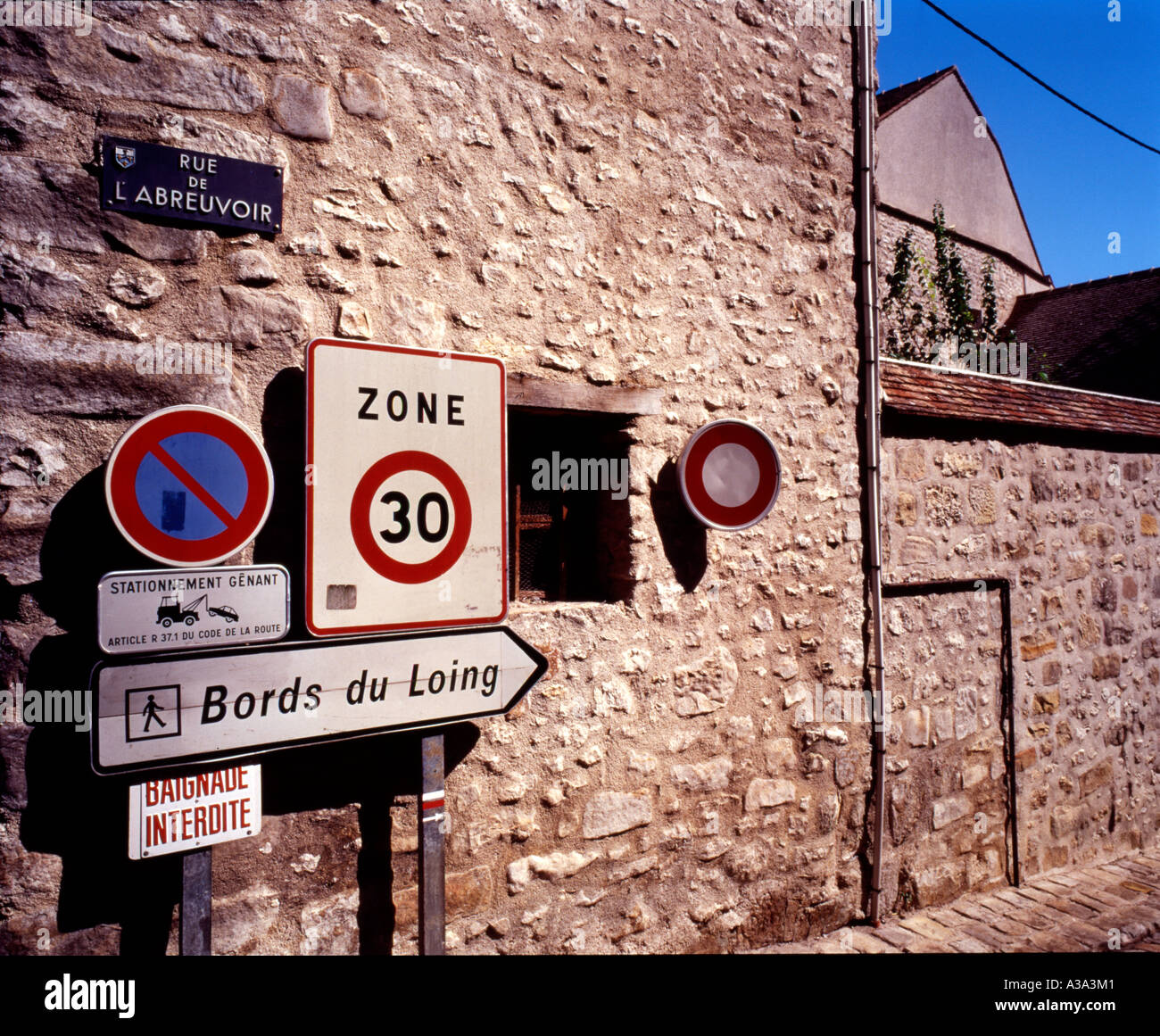 Rustic stone house wall in an old French town with street signs Stock ...