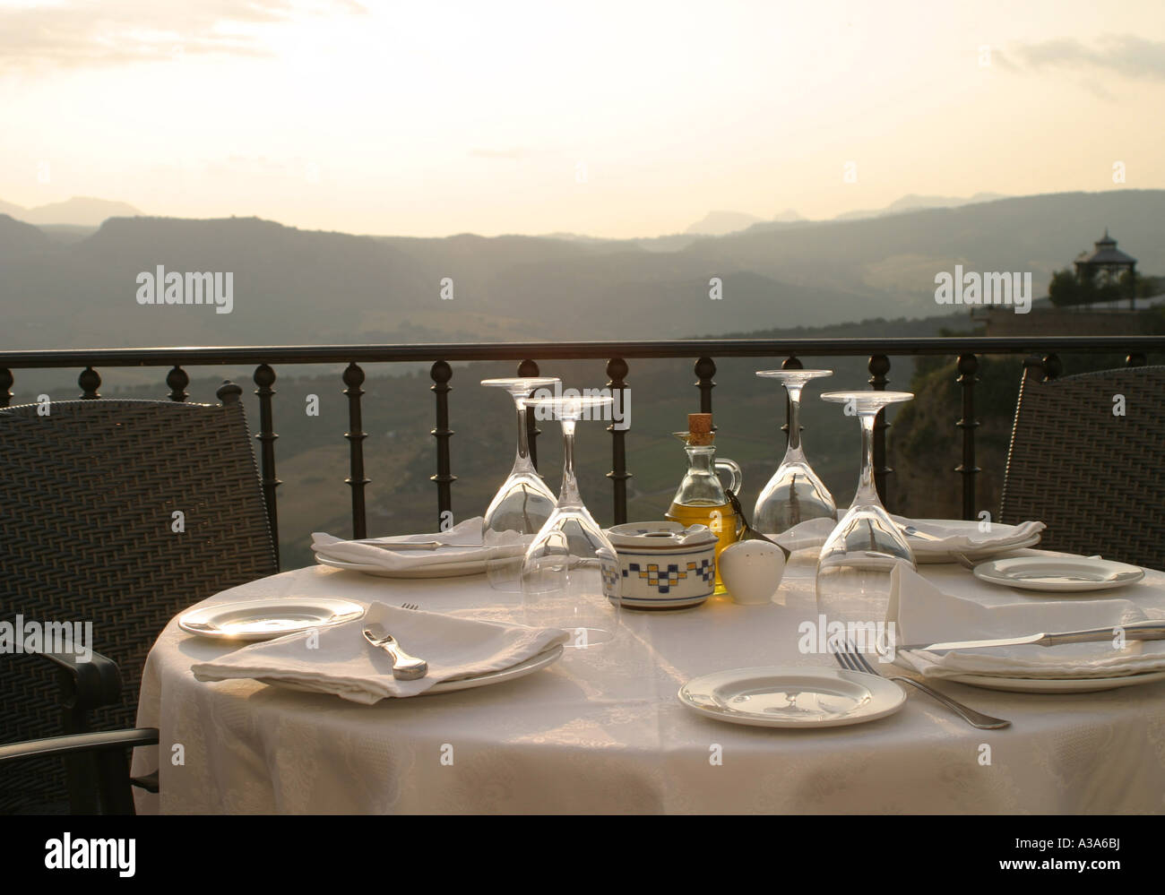 Dinner table set on balcony at sunset Stock Photo - Alamy