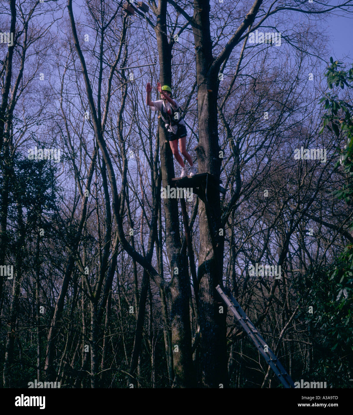 Teenage girl leaping to catch high wire trapeze on school outdoor ...