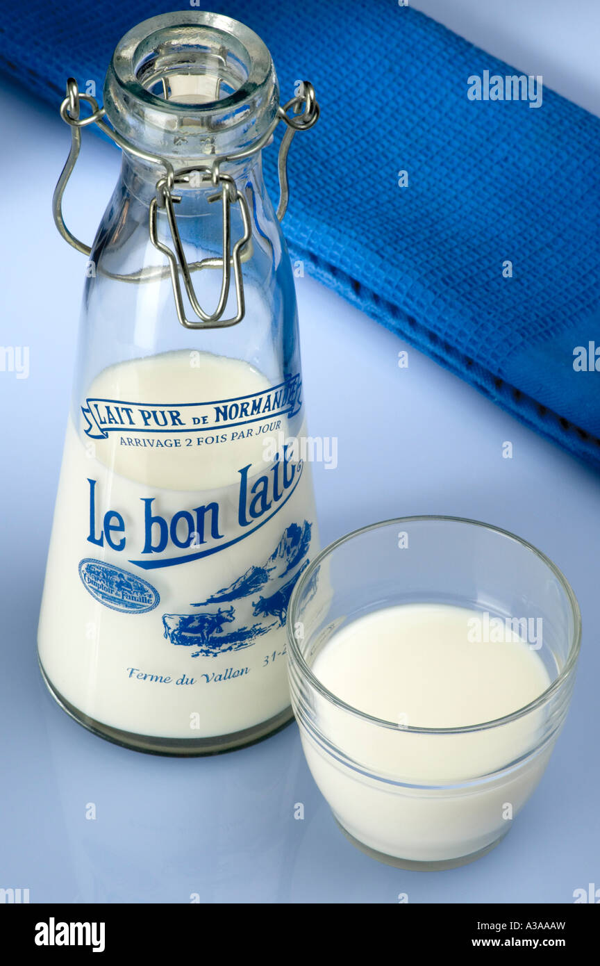 French traditional glass milk bottle with stopper, open, and glass of ...