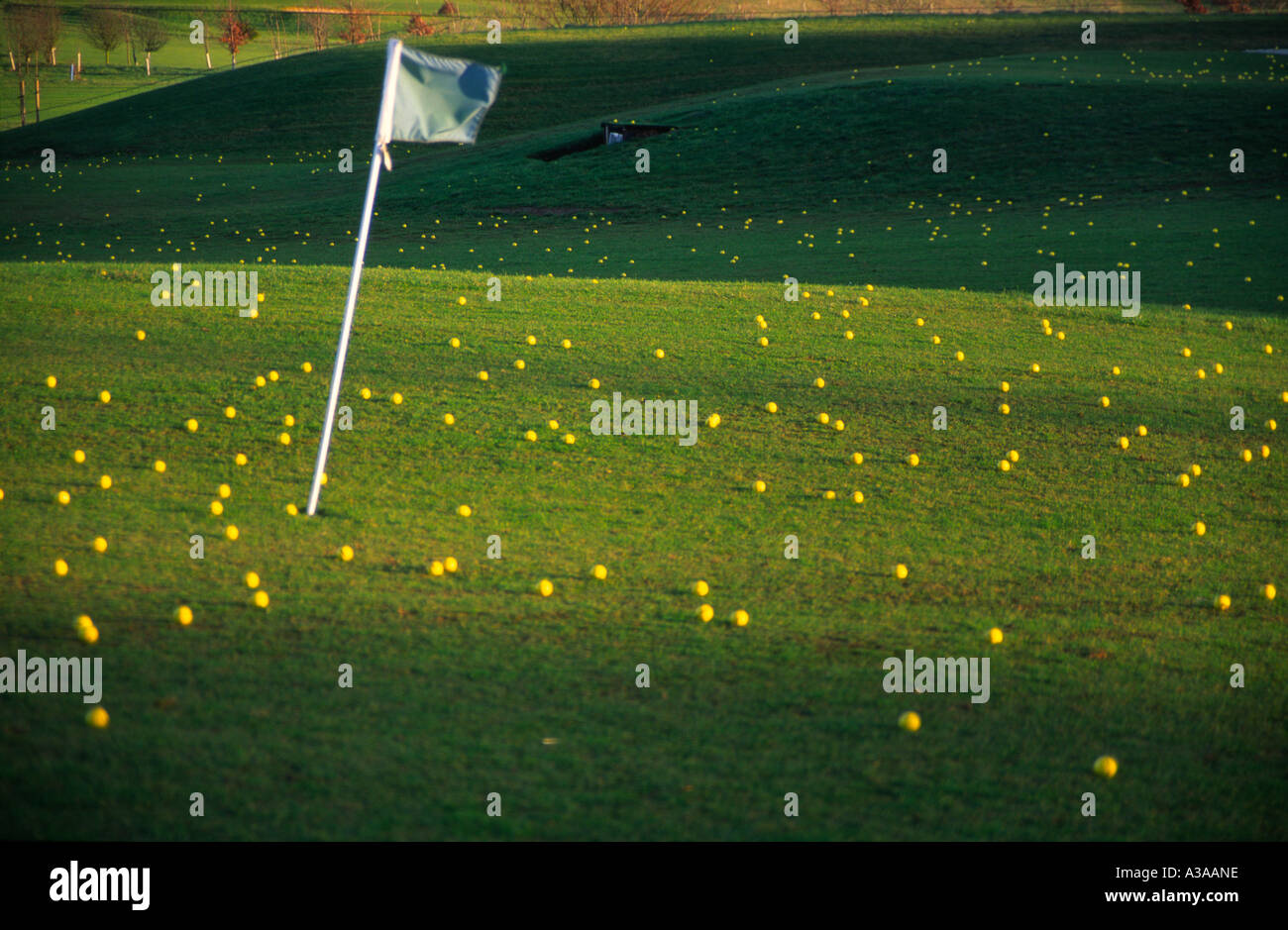 Golf course driving range with yellow balls over the fairway and greens ...