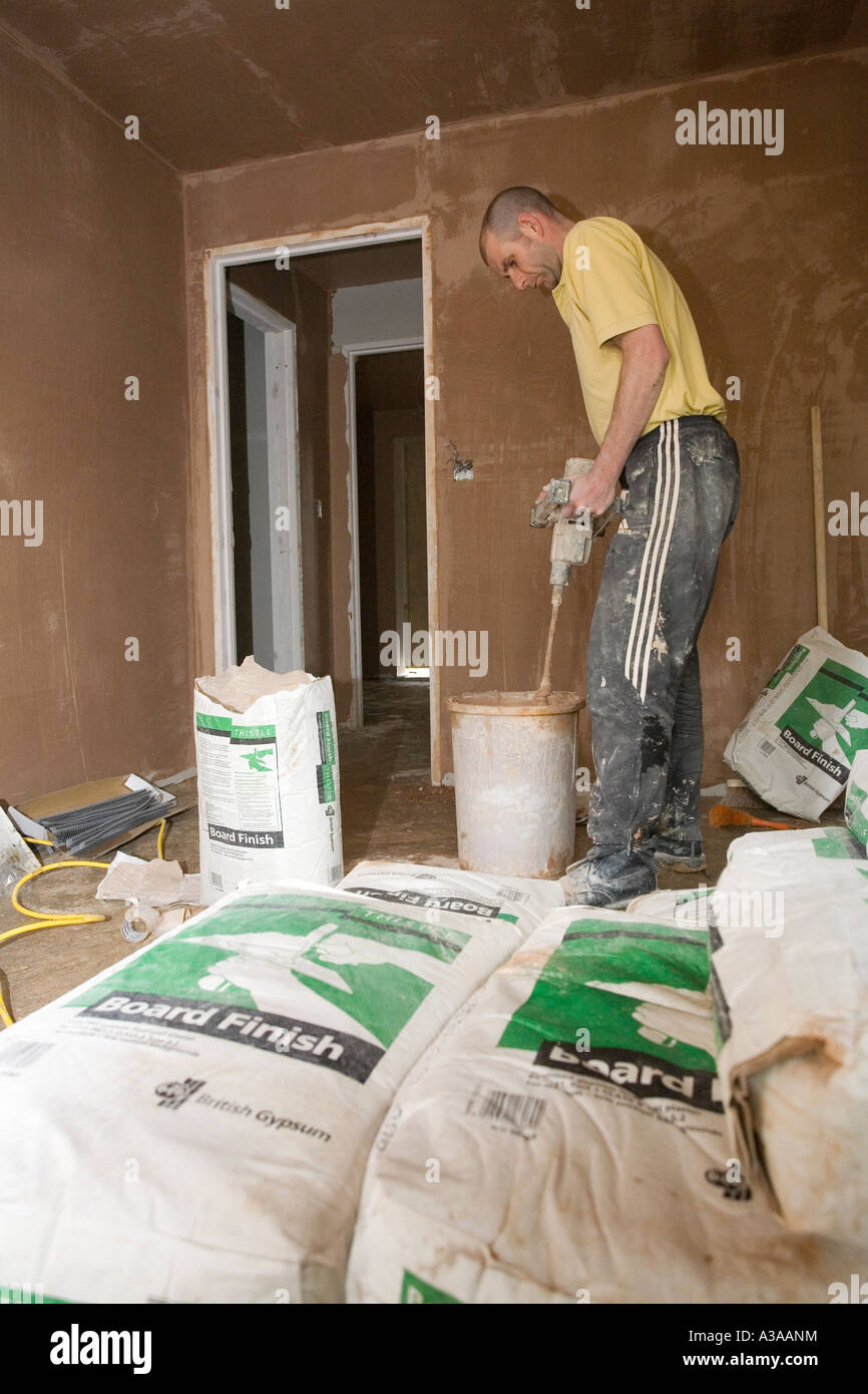 A plasterer mixing plaster in a newly built house, UK Stock Photo - Alamy