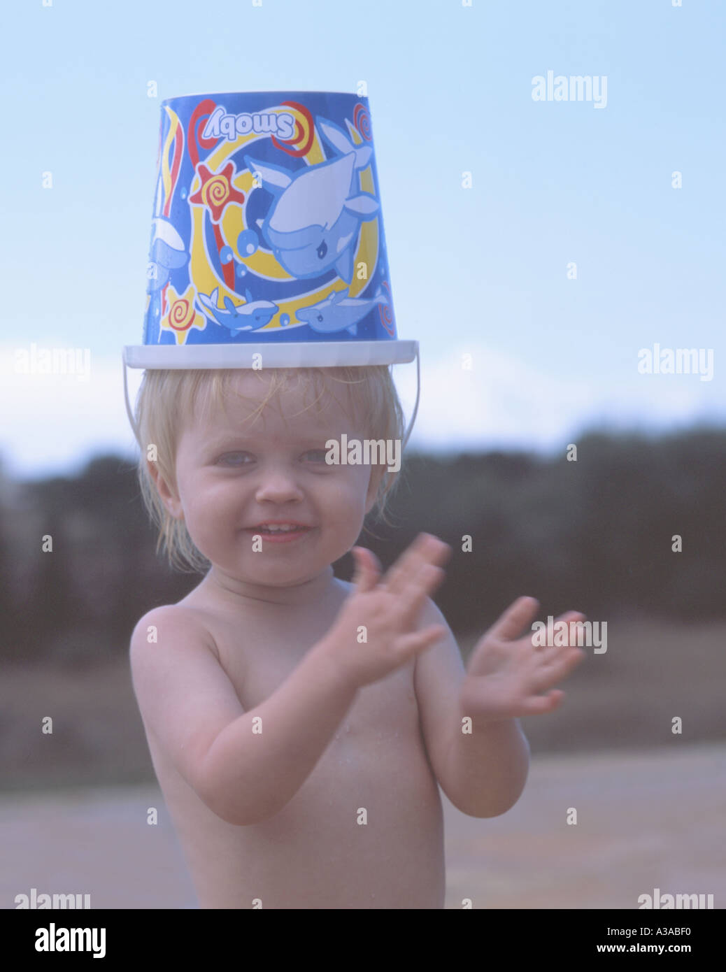 Child with bucket on head clapping Stock Photo - Alamy
