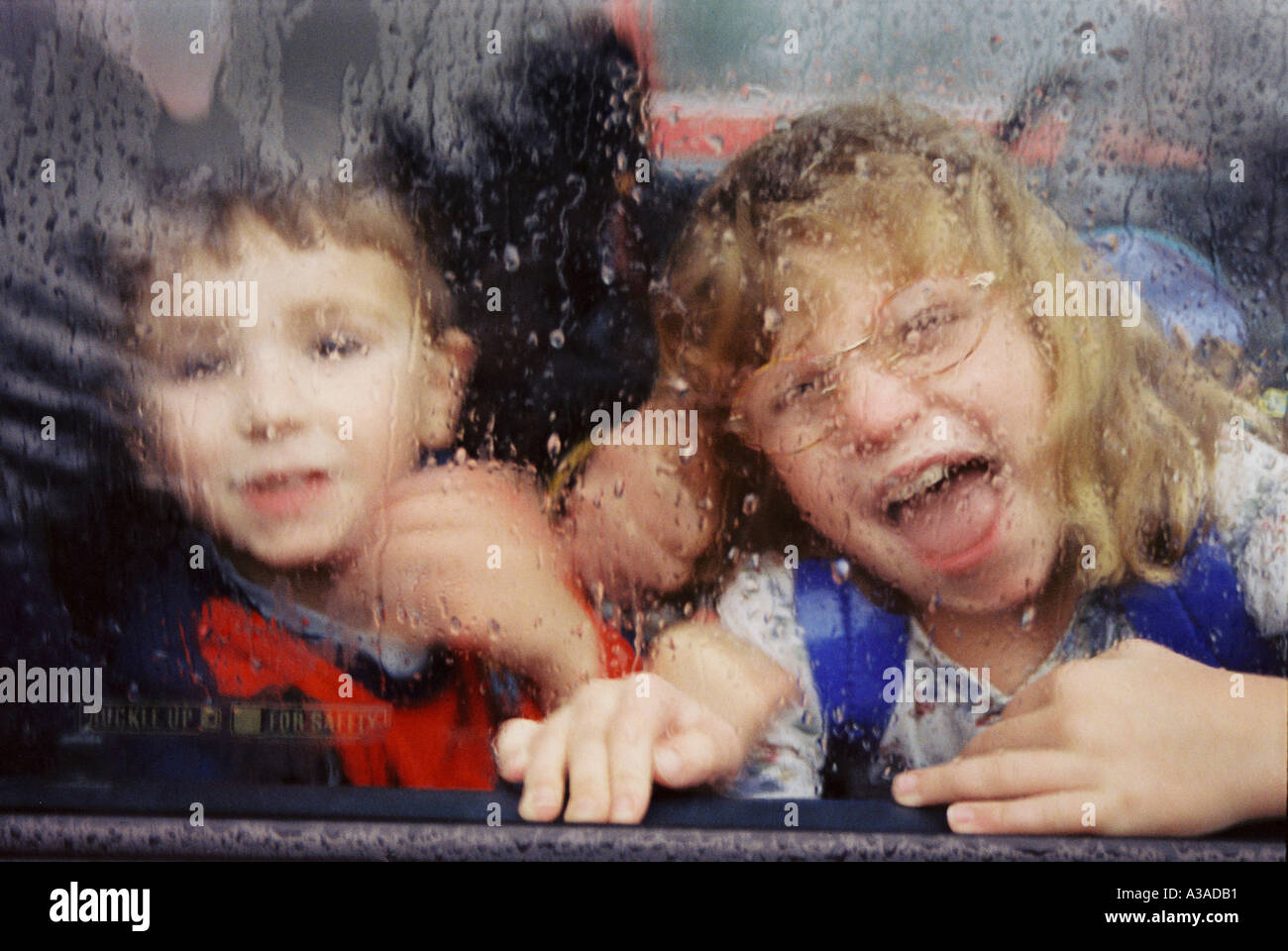 Children making funny faces through window on rainy day Stock Photo - Alamy