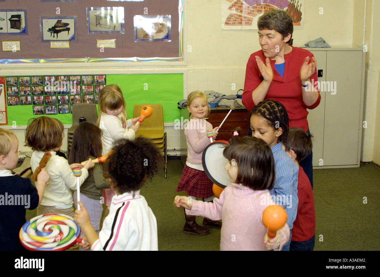 nursery school girls and boys clapping and singing in class Stock Photo ...