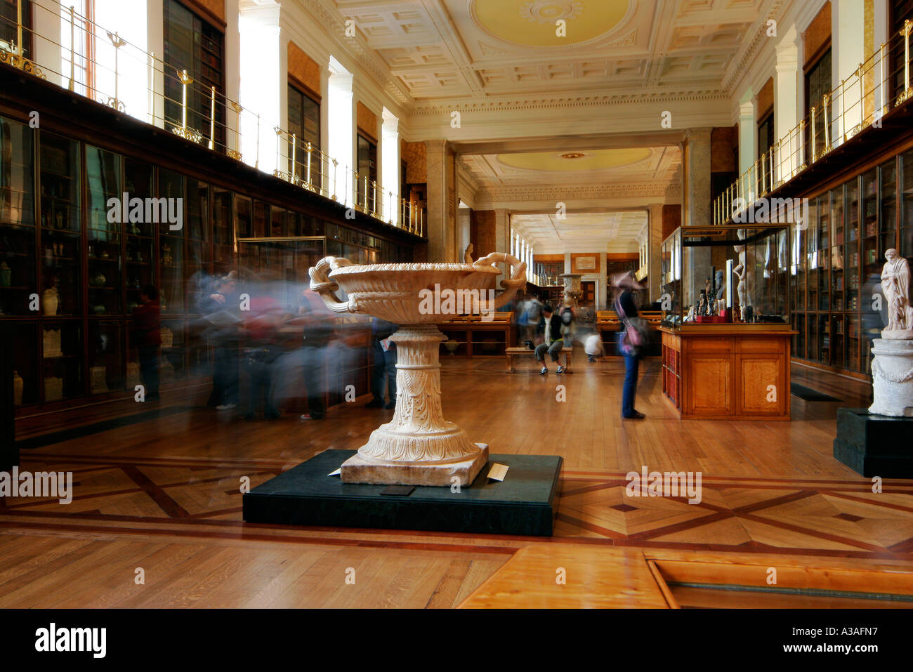 Visitors to the British Museum swirl around a marble Greek Urn in one ...
