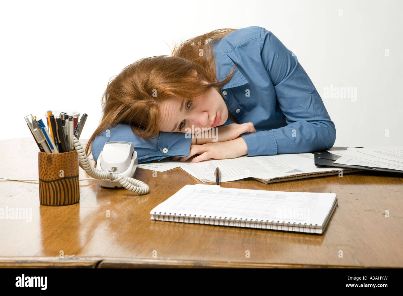 Woman resting her head on her desk Stock Photo - Alamy