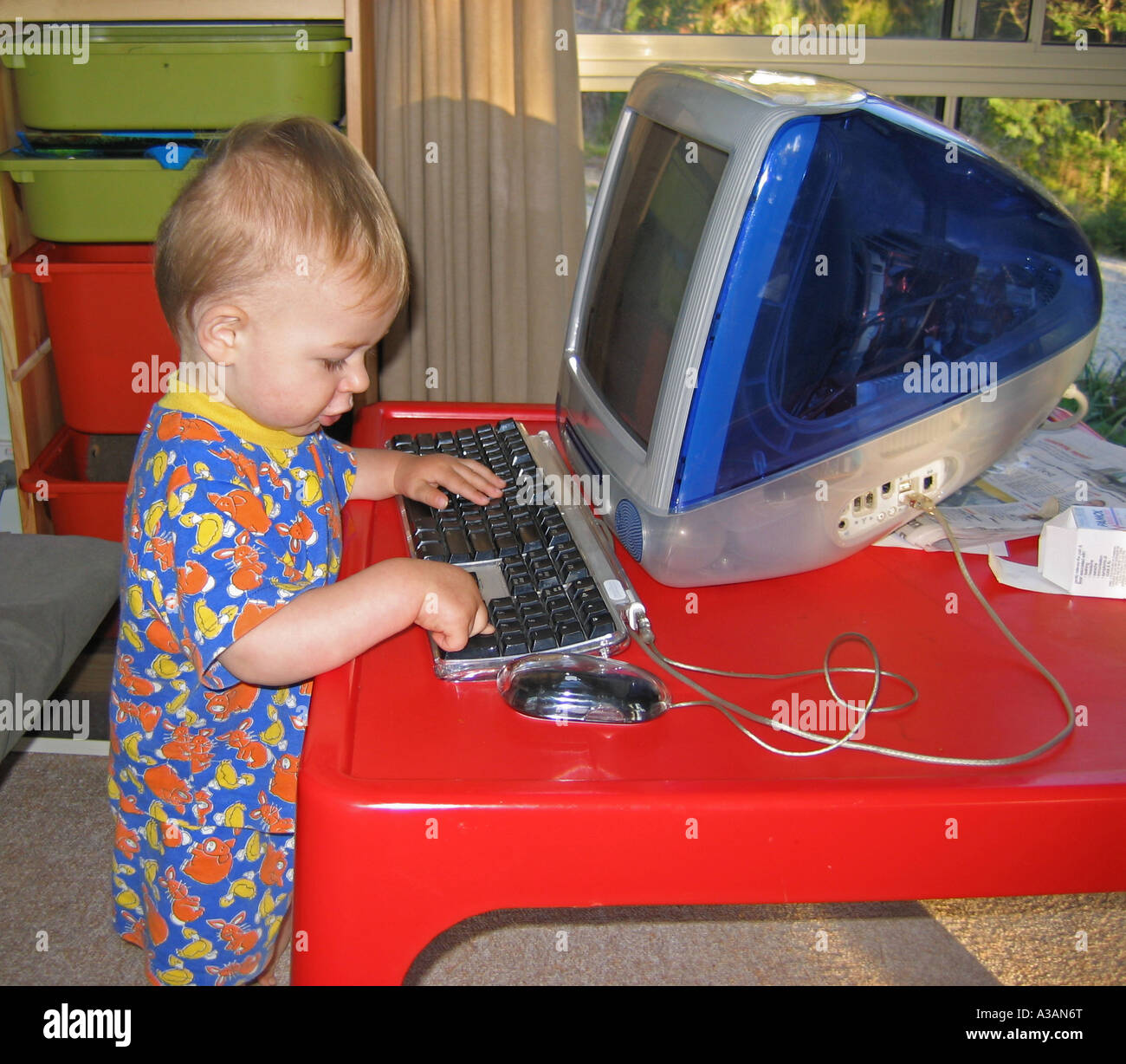 Young boy sitting at a Mac computer Stock Photo - Alamy