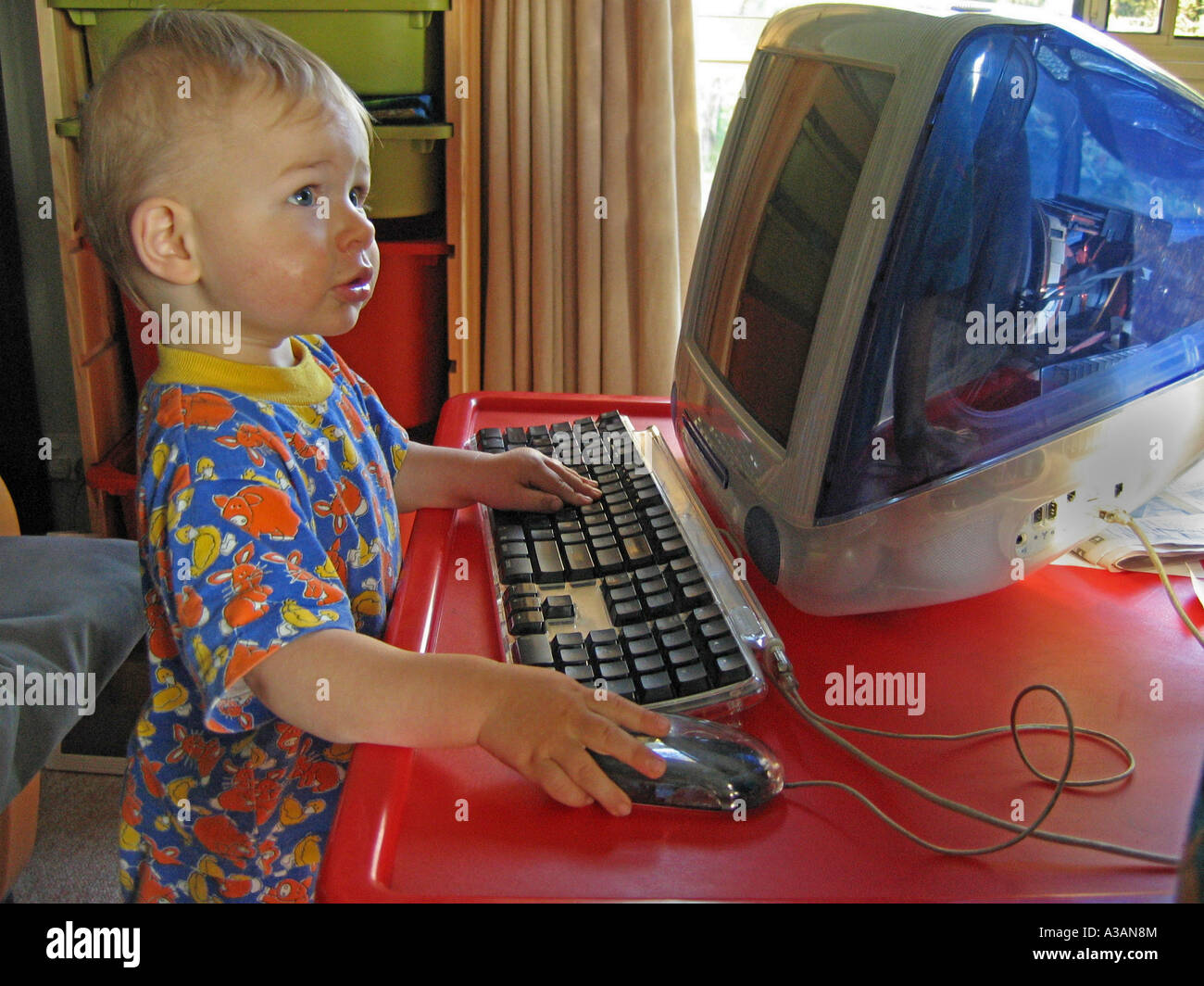 Young boy sitting at a Mac computer Stock Photo - Alamy