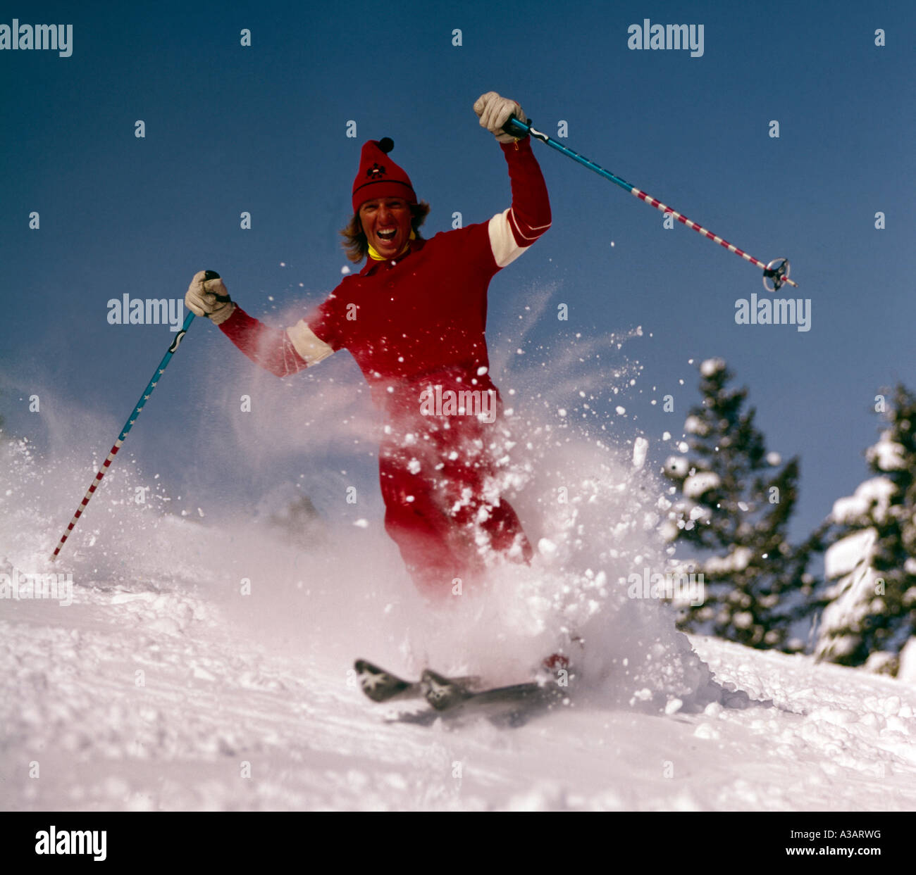 Steve Maw throws up powder snow making a turn on a sunny day at Sun ...