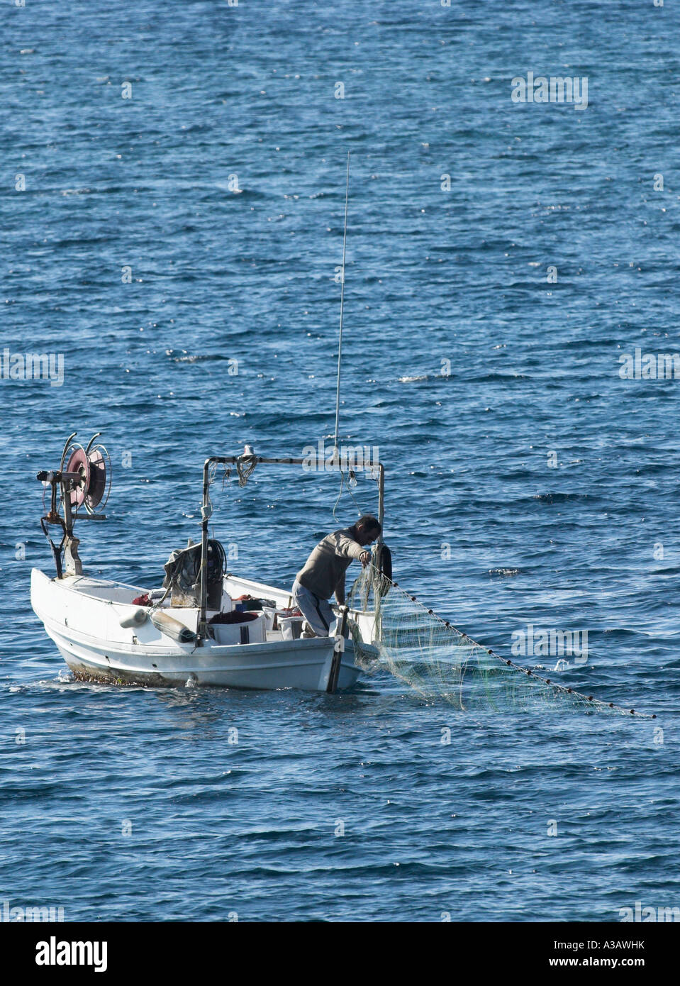 Fisherman Casting fishing net off the stern of his boat. Paphos Cyprus ...