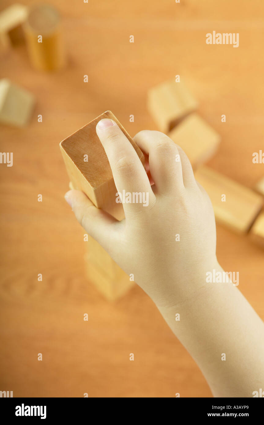 A child stacking wooden toy blocks Stock Photo - Alamy