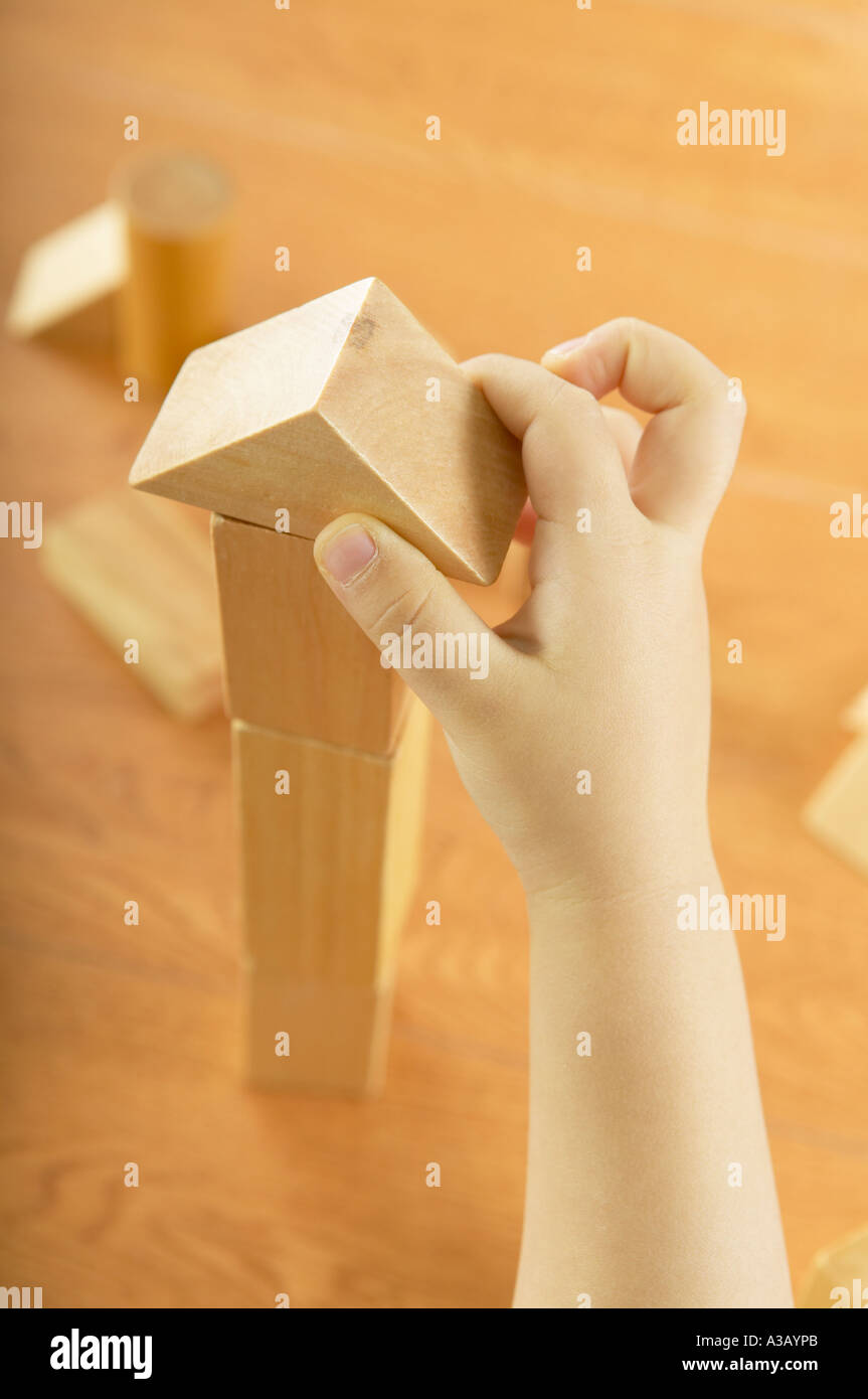 A child stacking wooden toy blocks Stock Photo - Alamy