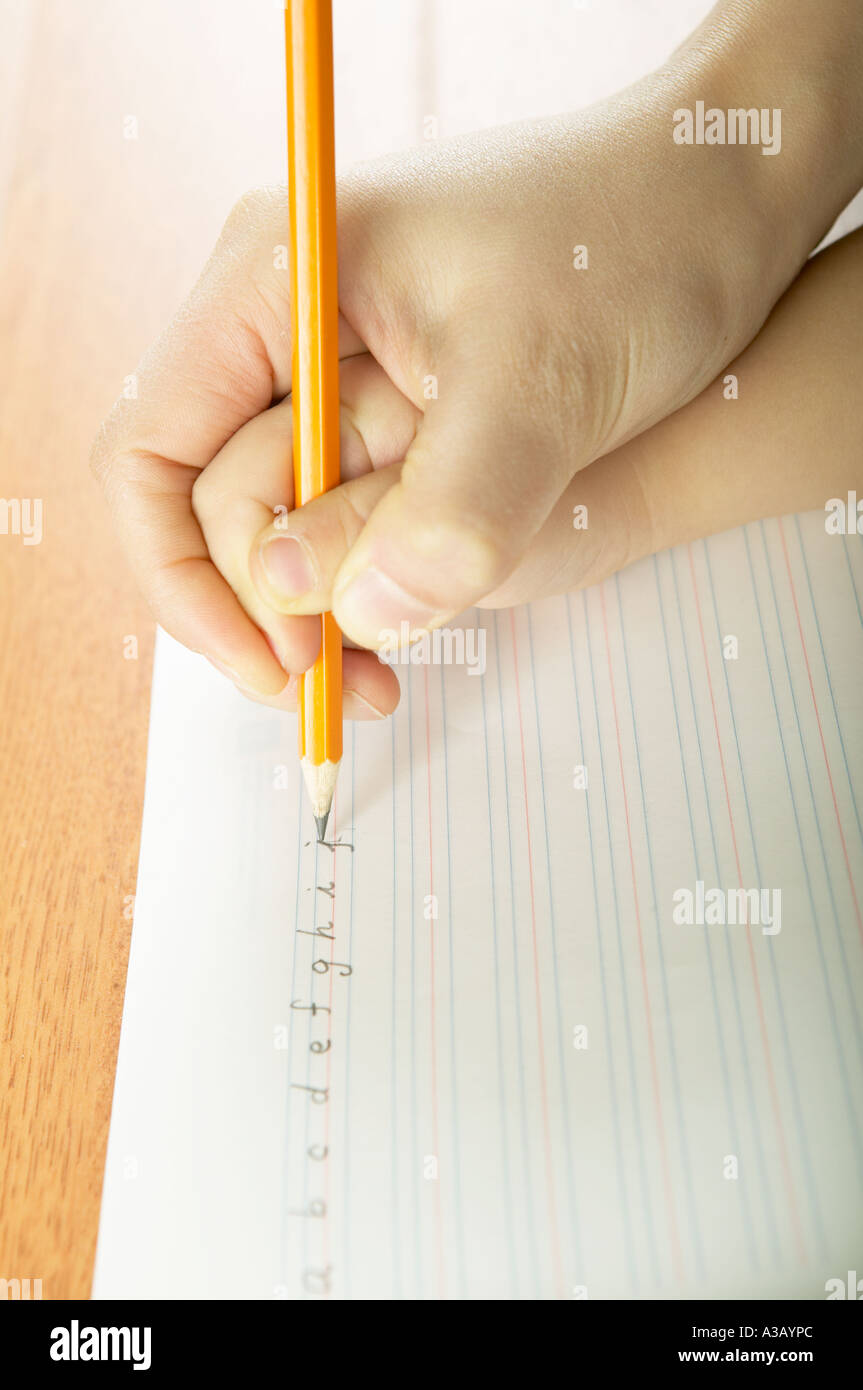 An adult helping a child with writing Stock Photo - Alamy