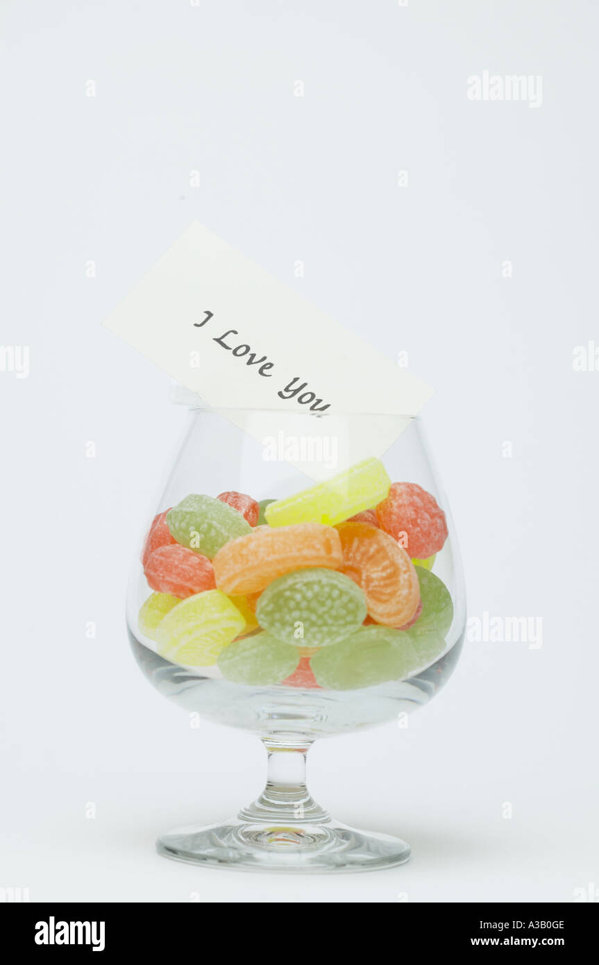 Candies and a greetings note in the glass in white background Stock ...