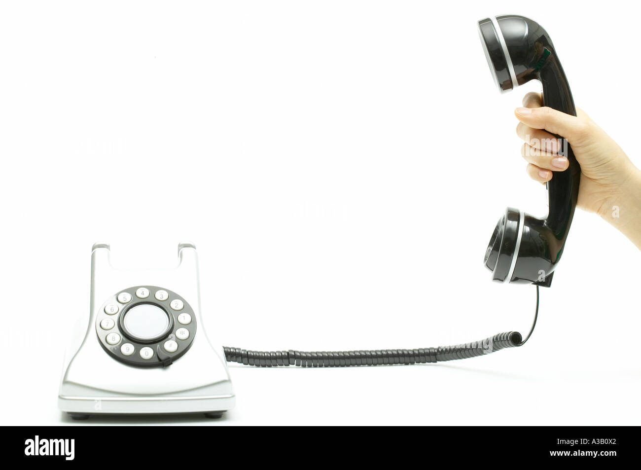 A hand holding the handset of telephone Stock Photo - Alamy