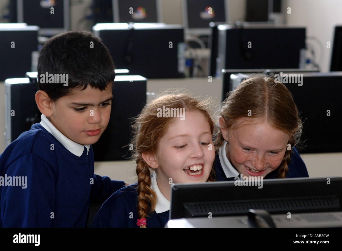 Primary school children use a computer in the IT Suite Stock Photo - Alamy