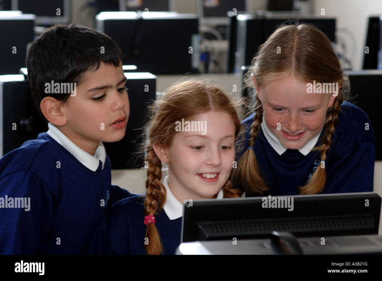 Primary school children use a computer in the IT Suite Stock Photo - Alamy