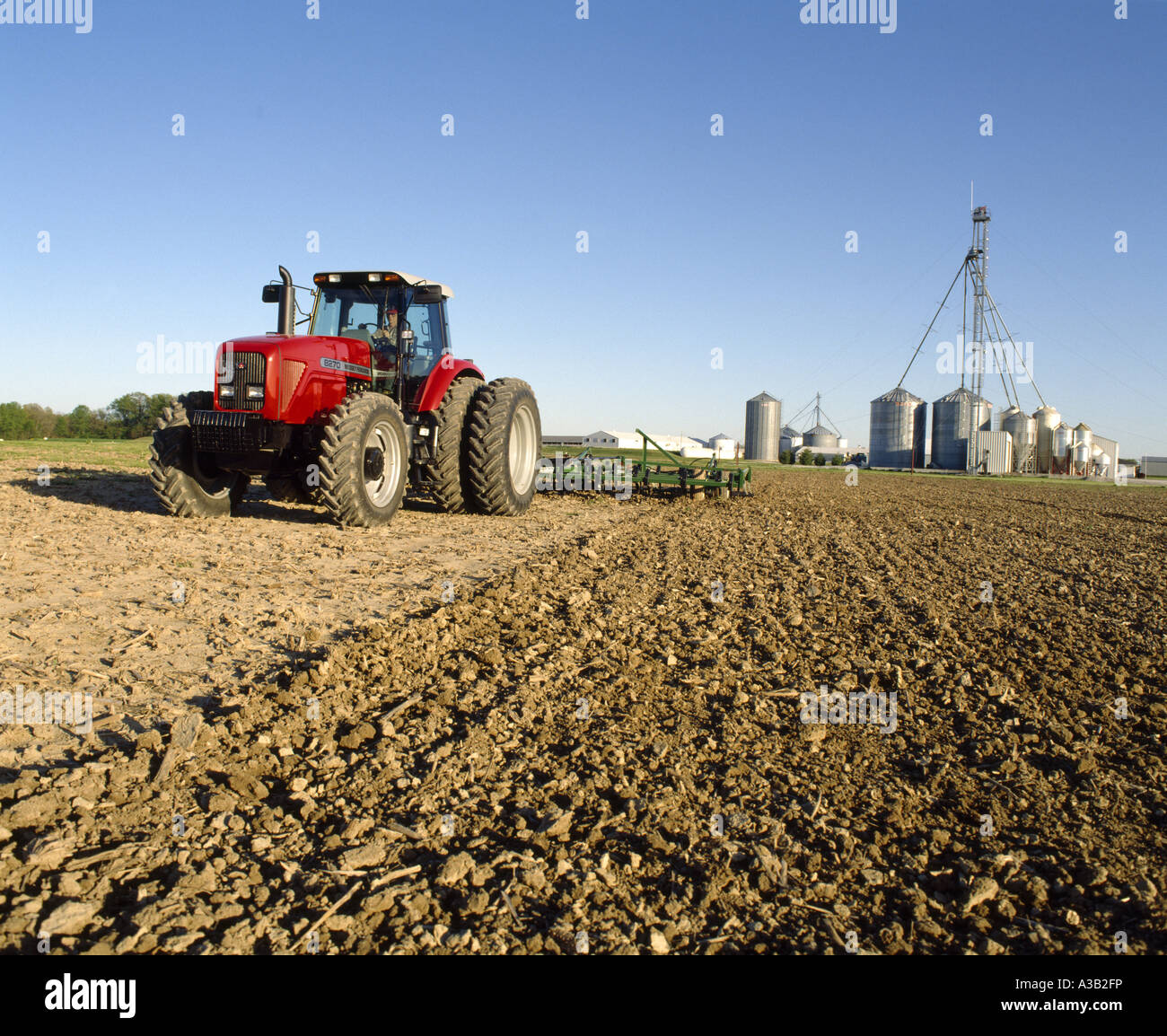 FIELD BEING PREPARED FOR SPRING PLANTING WITH FIELD CULTIVATOR ATTACHED ...