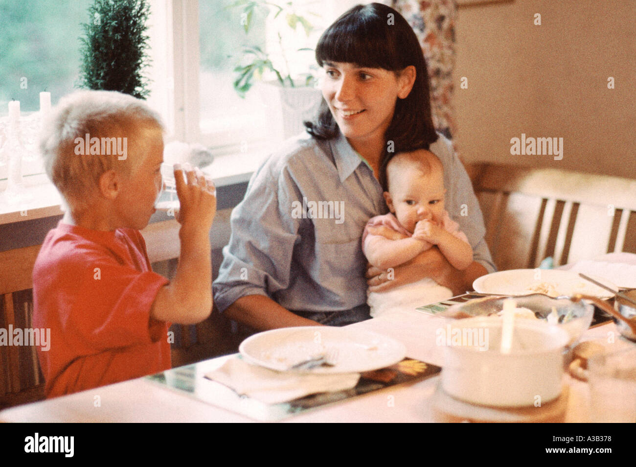 Mother talking to kids at dinner table hi-res stock photography and ...